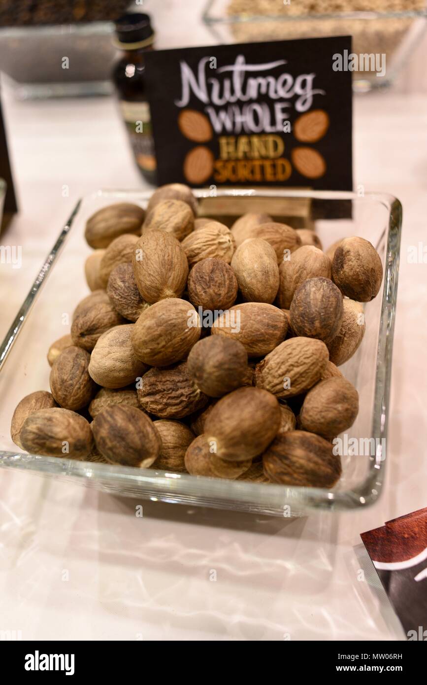 Bowl of whole nutmeg (Myristica fragrans) spice on table display of ...
