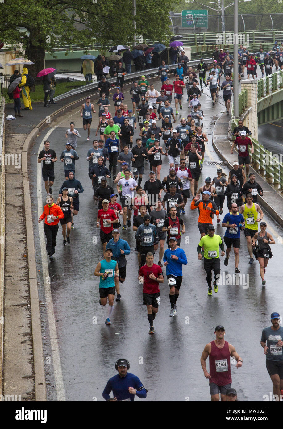 Runners race through the rain entering Ocean Parkway at the 7 mile mark ...