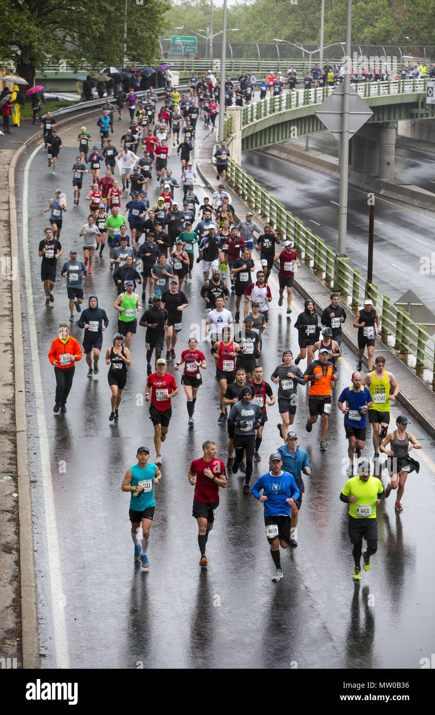 Runners race through the rain entering Ocean Parkway at the 7 mile mark ...