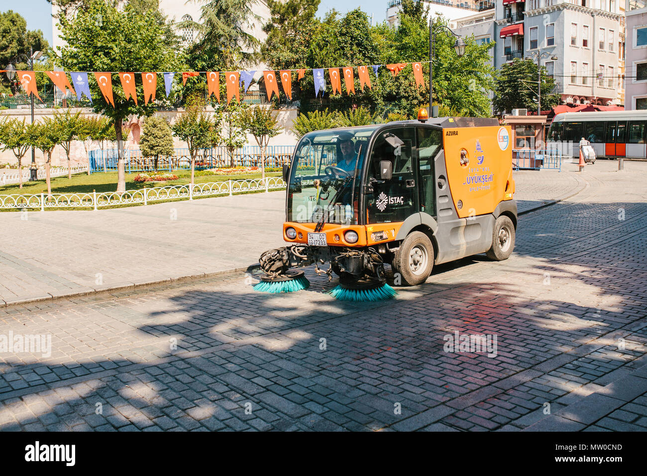 Editorial image of street janitor using cleaning machine to sweep and ...