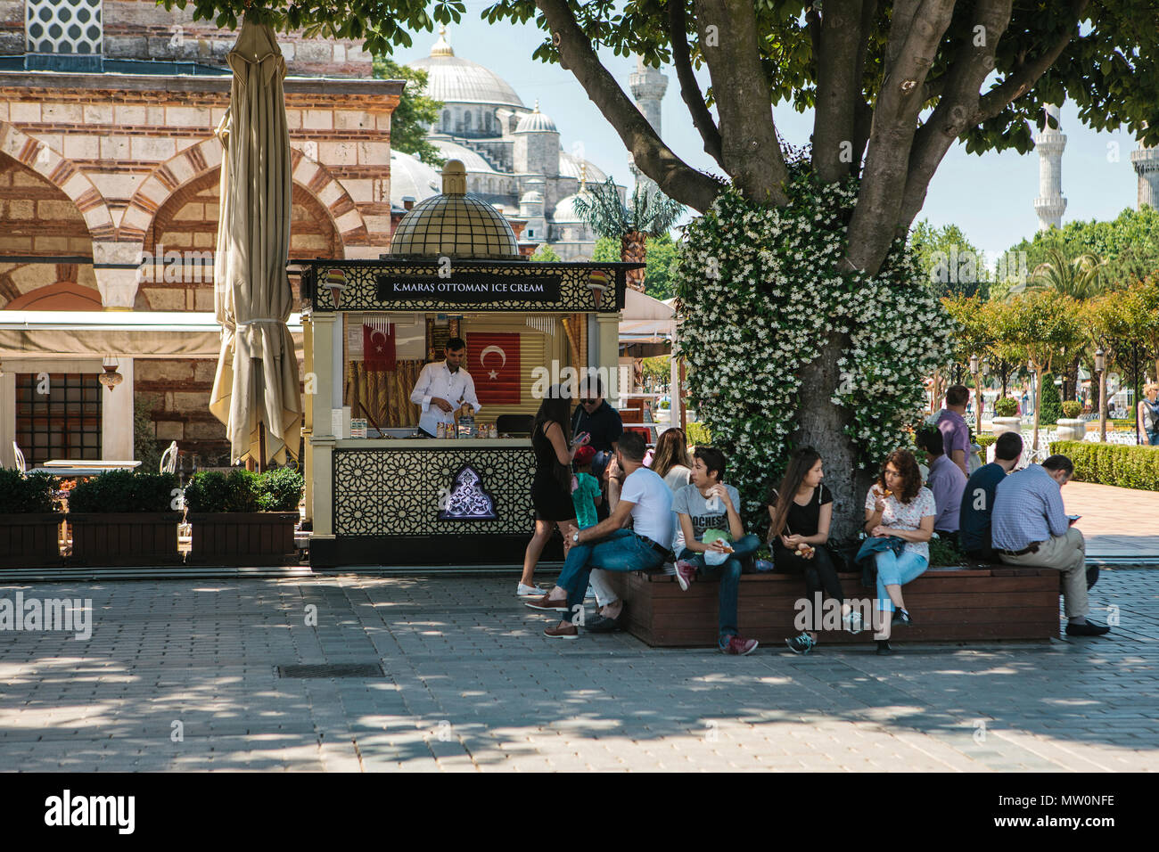 Editorial image of group of people resting on a bench around beautiful ...
