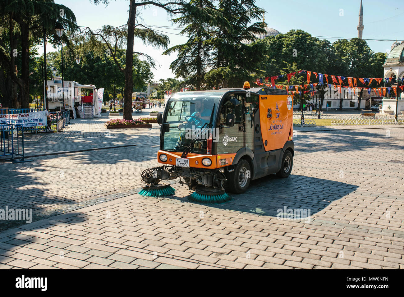 Editorial image of street janitor using cleaning machine to sweep and ...