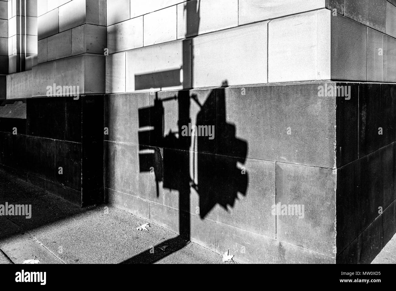 Shadow of traffic light on a wall on street corner in black and white ...