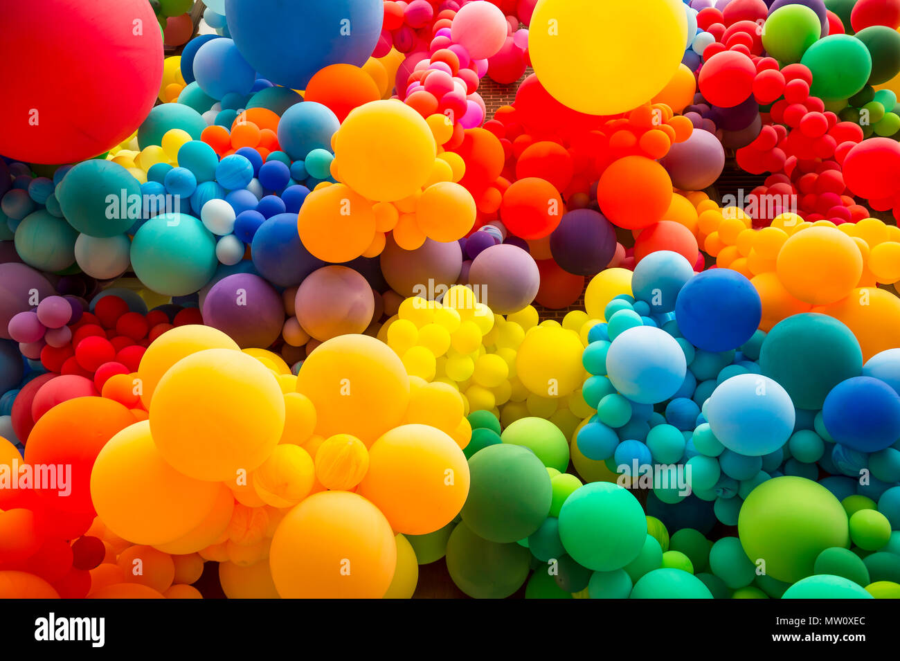 Bright abstract background of jumble of rainbow colored balloons ...