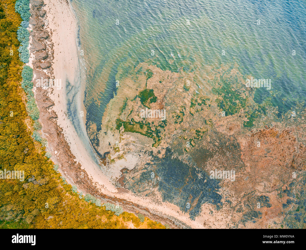 Aerial view looking down at beautiful rocks in shallow ocean water ...