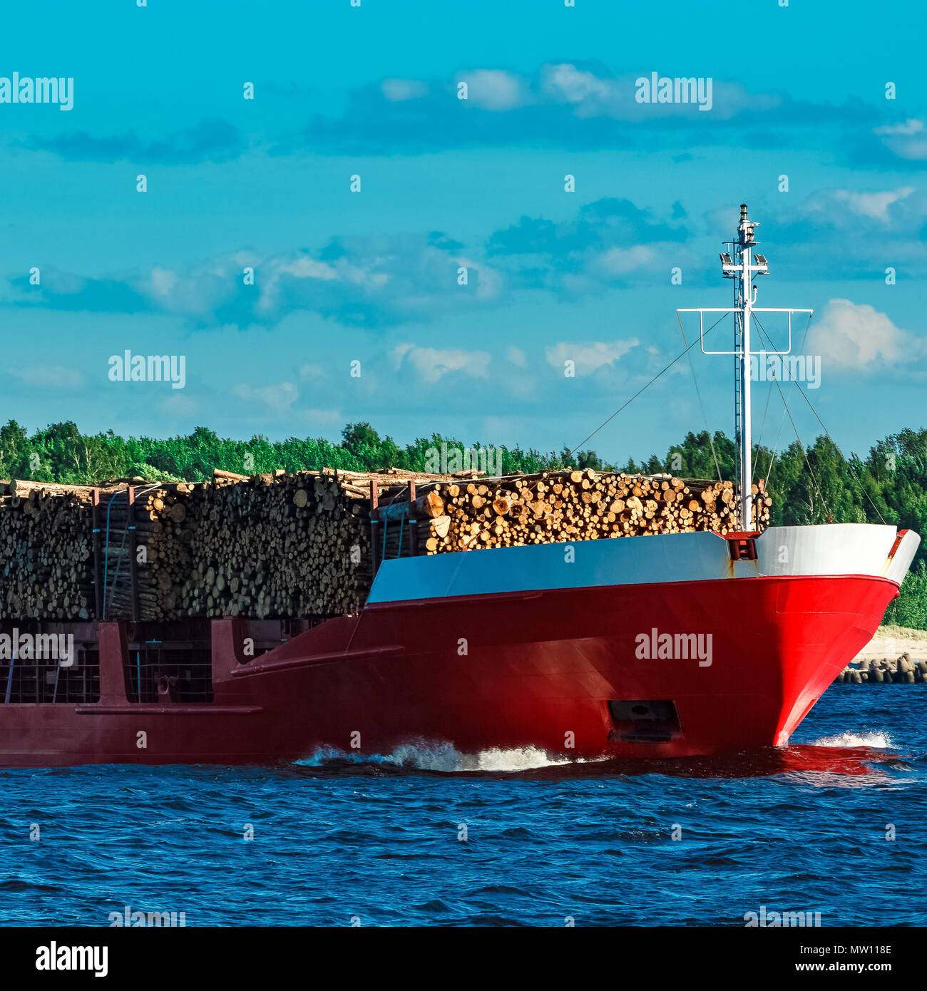 Red cargo ship fully loaded with wood moving at clear day Stock Photo ...