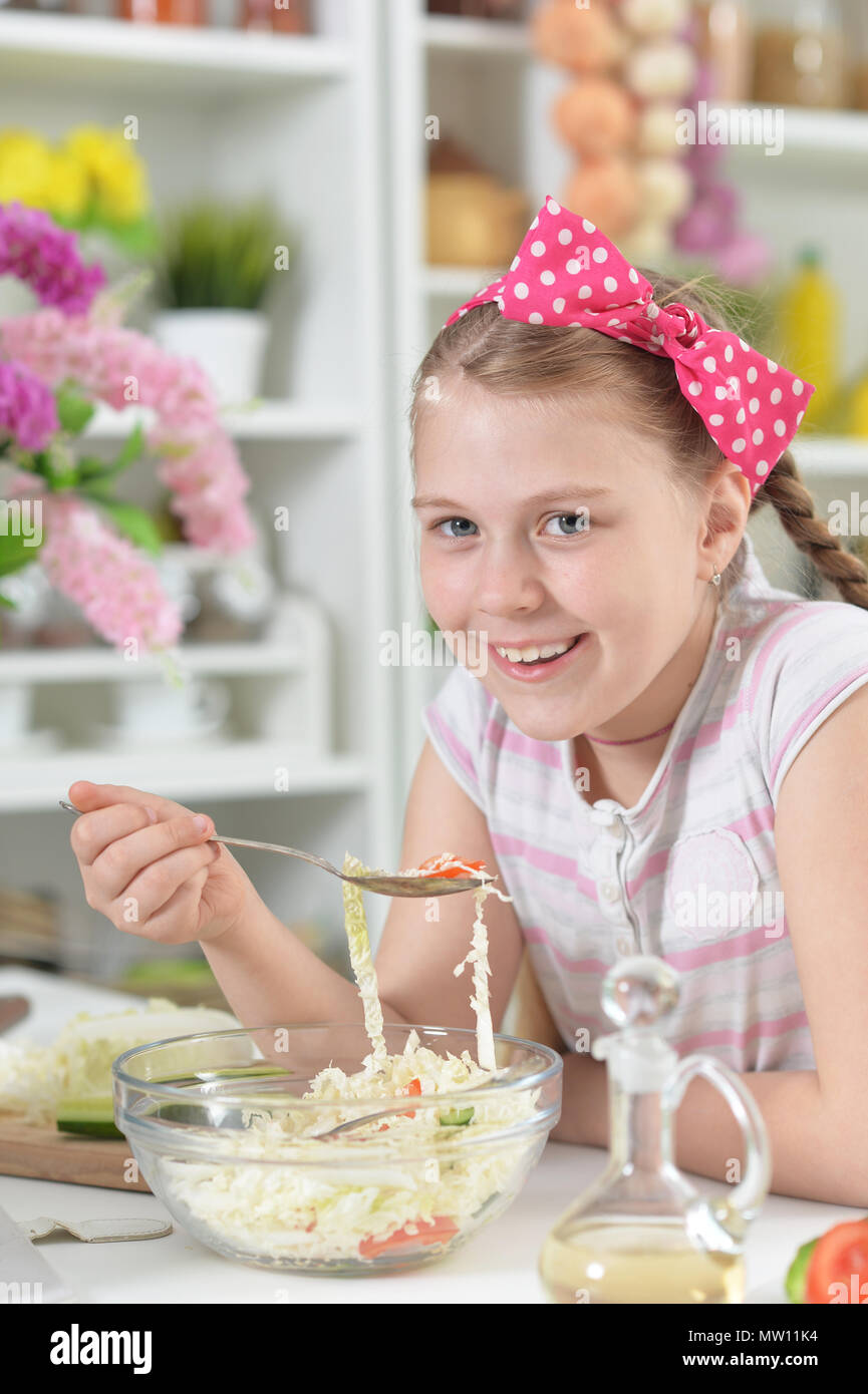 Cute girl eating delicious fresh salad Stock Photo - Alamy