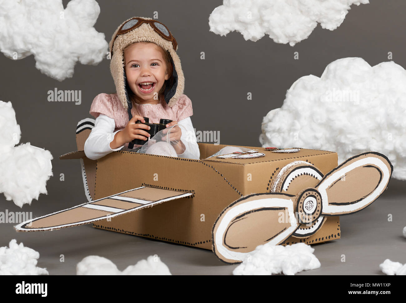 the child girl plays in an airplane made of cardboard box and dreams of ...