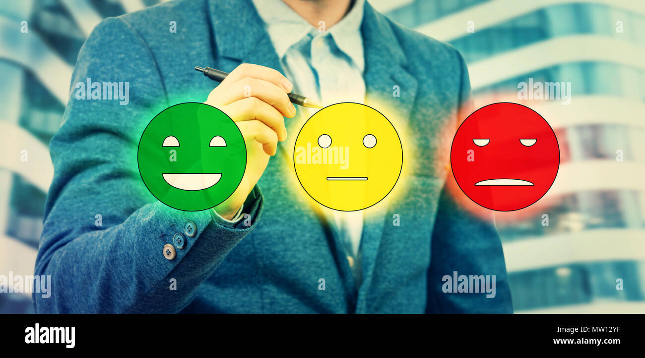 Young man close up holding a pen in hand choosing neutral face emoticon ...