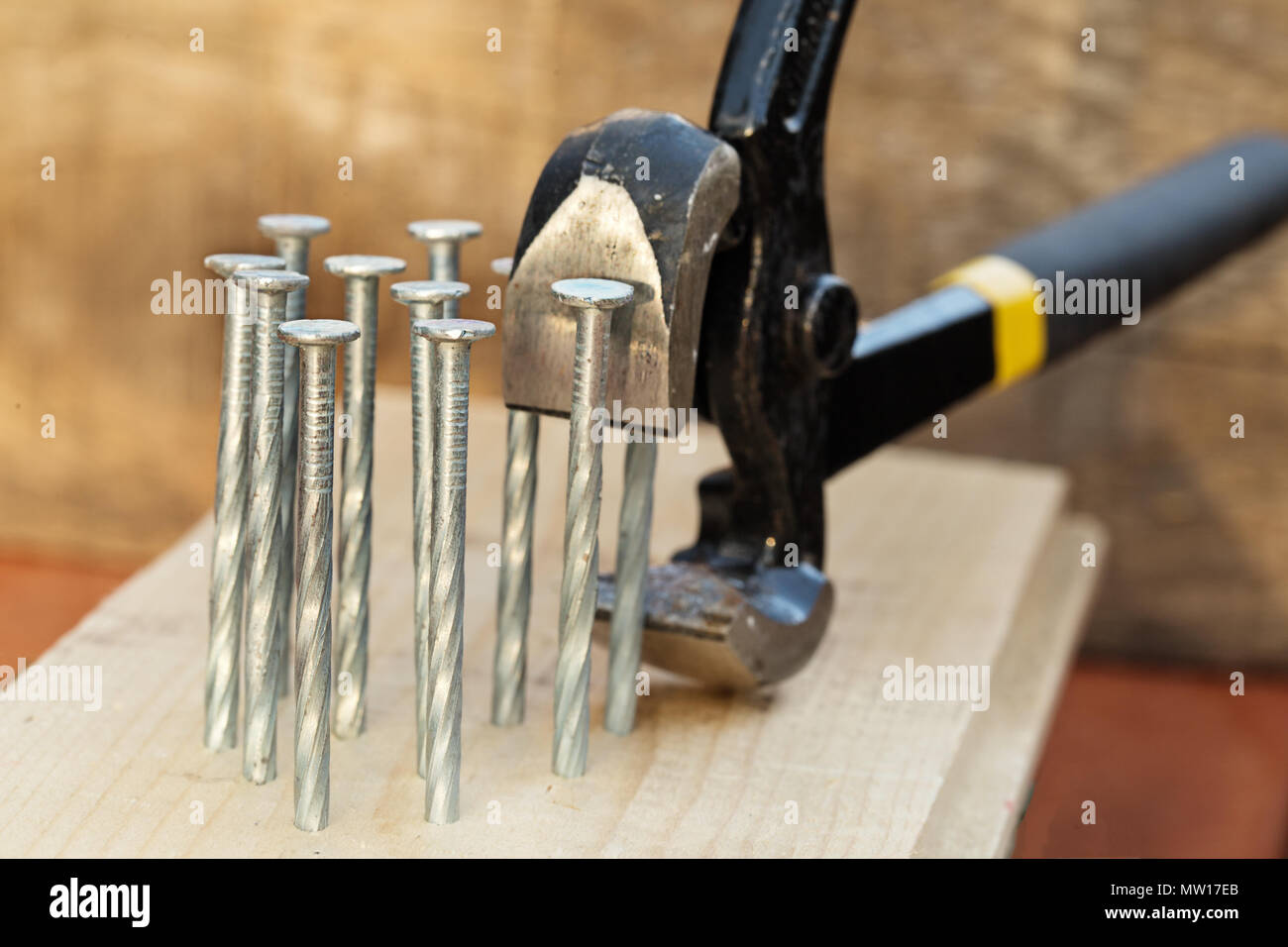 Pincers and nails close up. Nails are hammered into a board, pincers ...