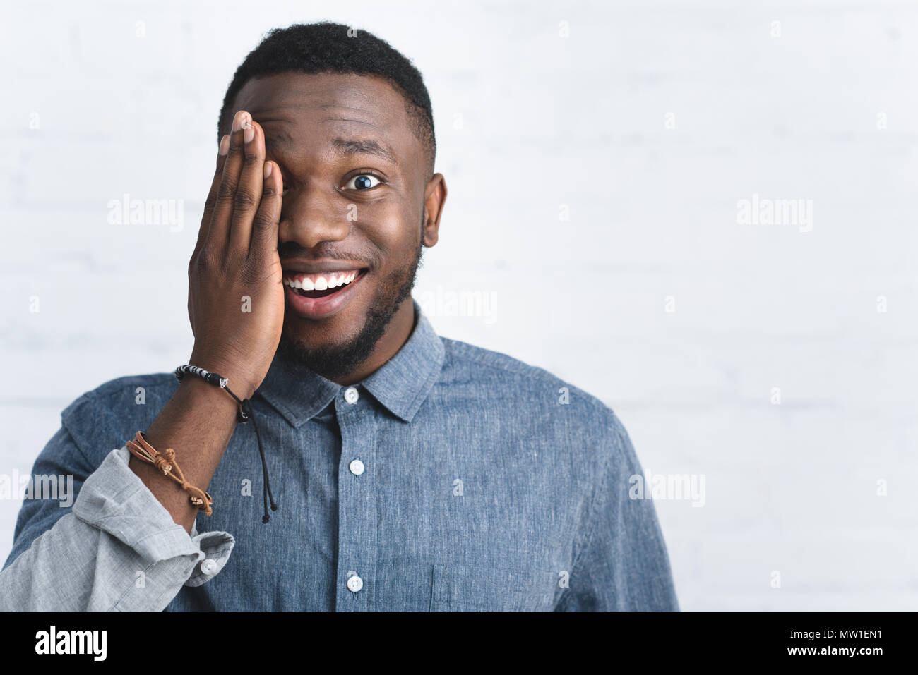 African american man covering half of face with hand Stock Photo - Alamy