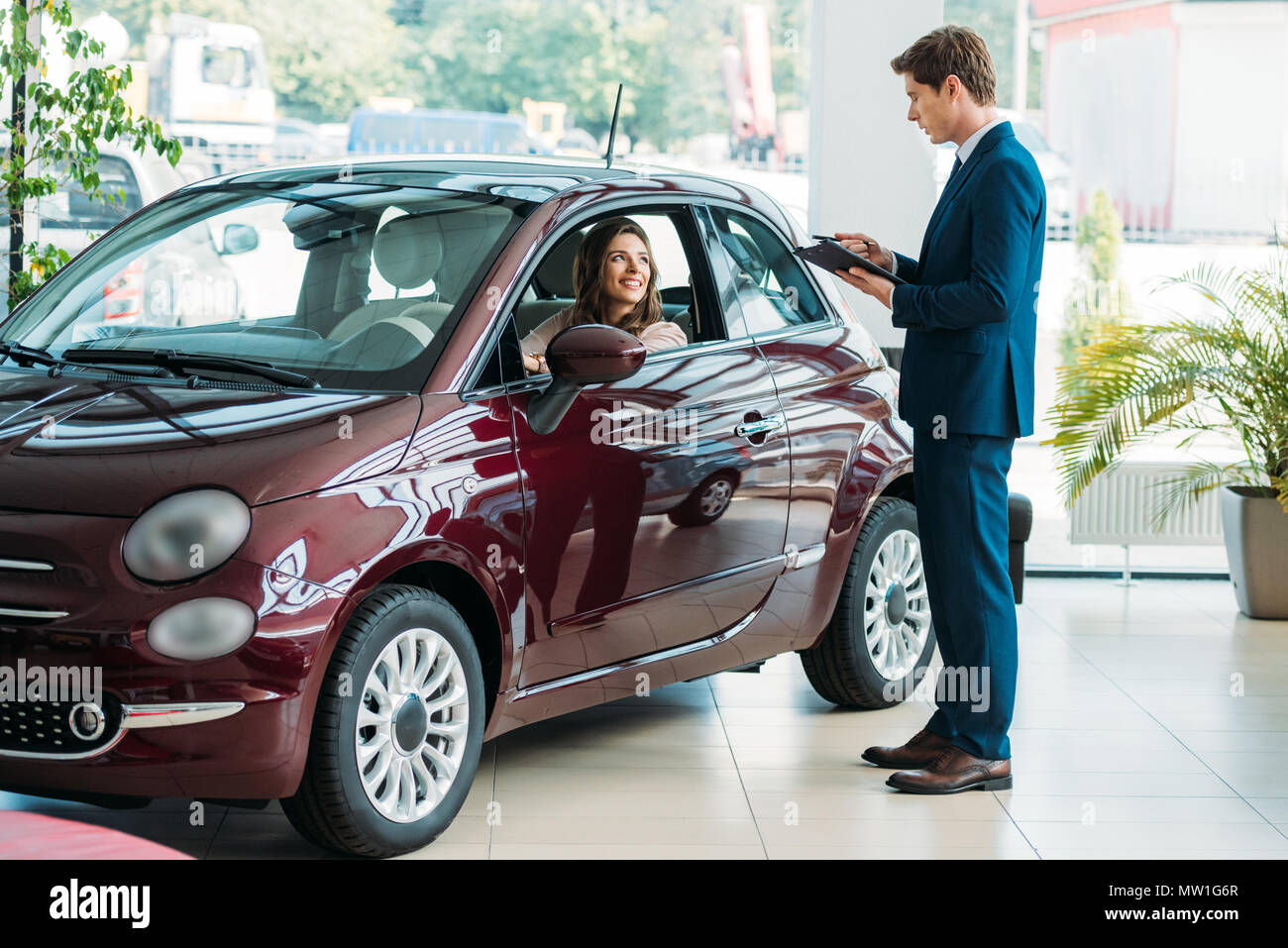 Manager talking with a smiling customer after test-driving a car Stock ...