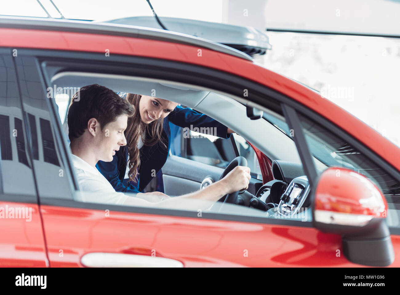 Manager speaking to customer sitting in a car for test-drive Stock ...