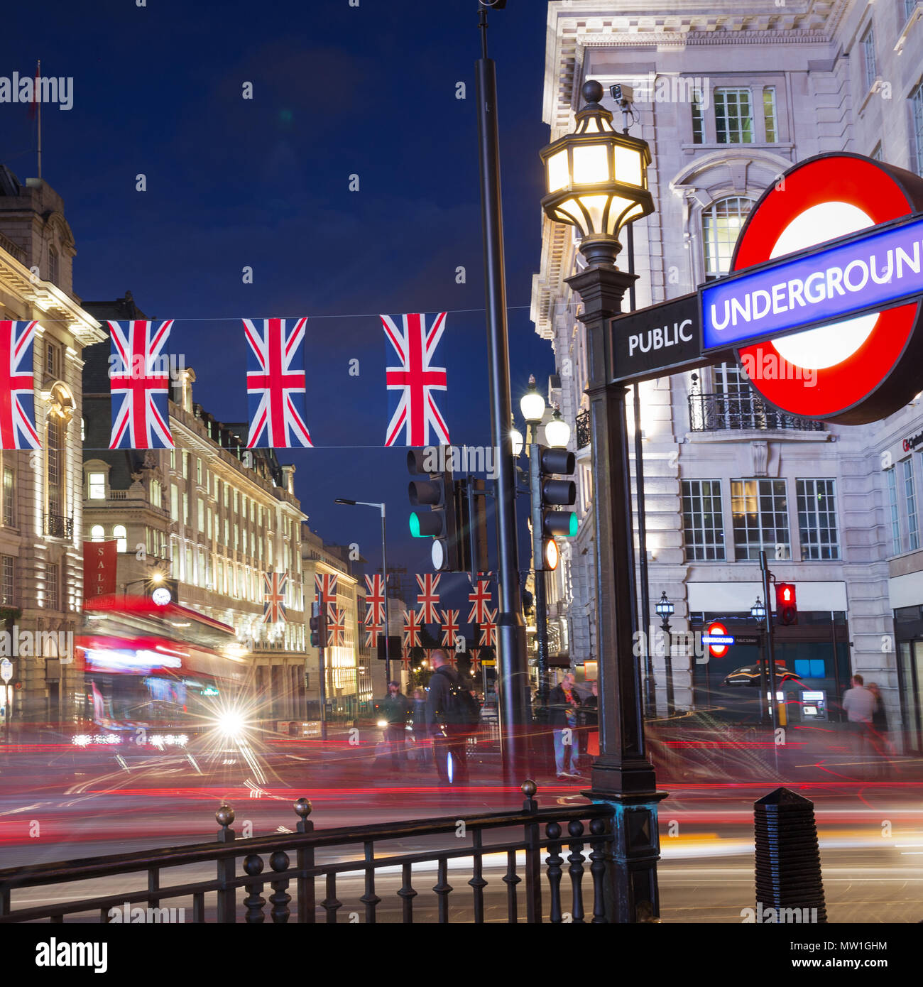 Popular tourist Picadilly circus with flags union jack in night lights ...