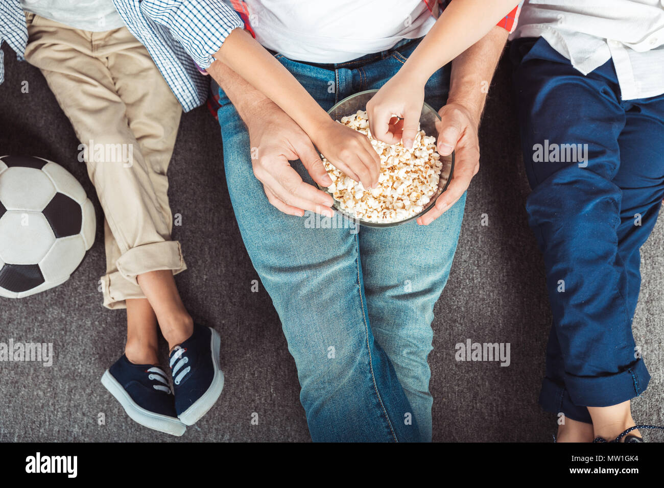 cropped shot of father with sons eating popcorn at home Stock Photo - Alamy