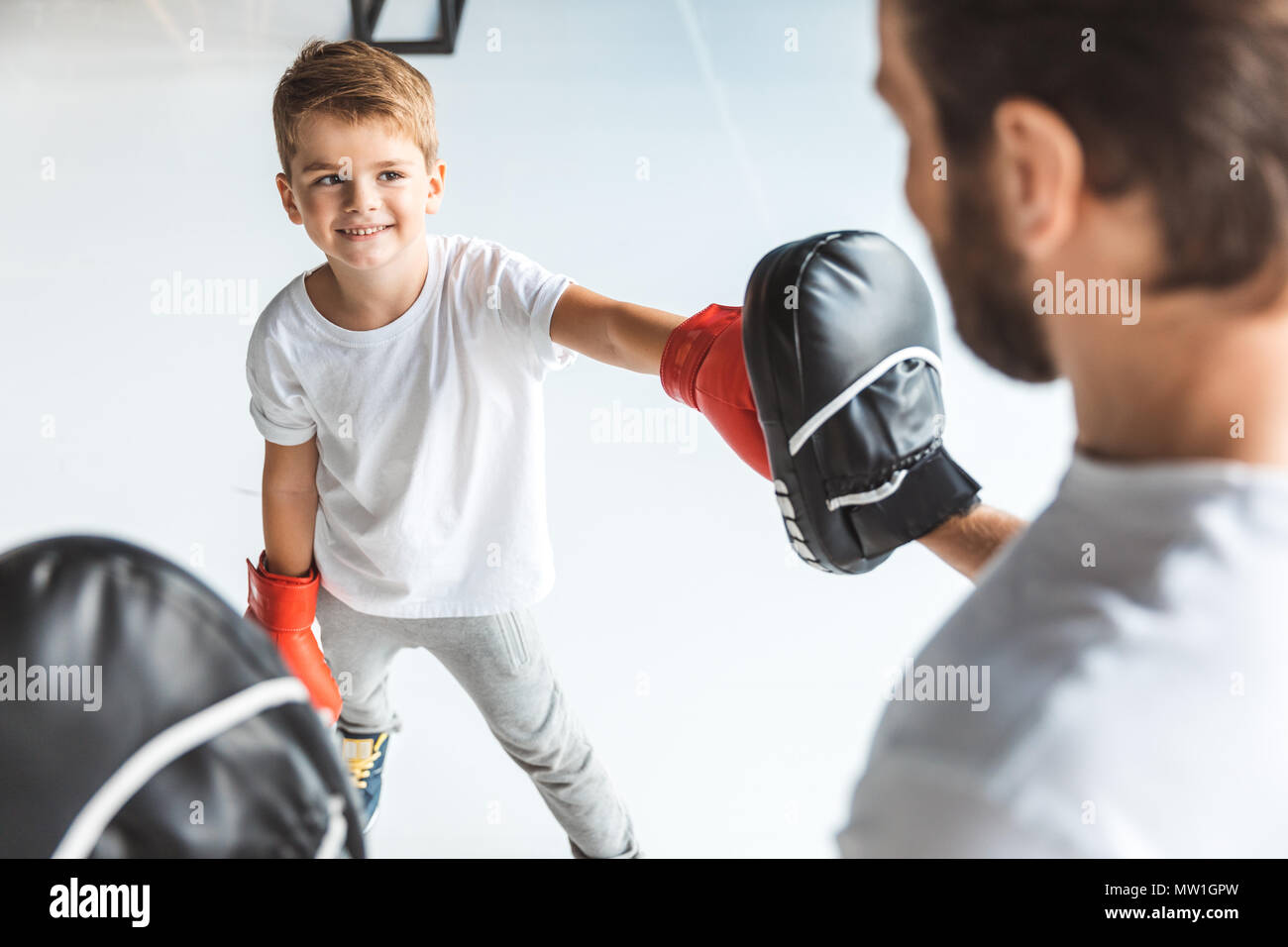selective focus of cute smiling boy boxing with father Stock Photo - Alamy