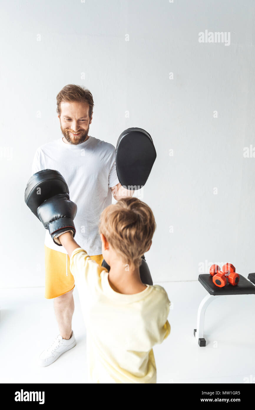 smiling father and little son boxing together on white Stock Photo - Alamy