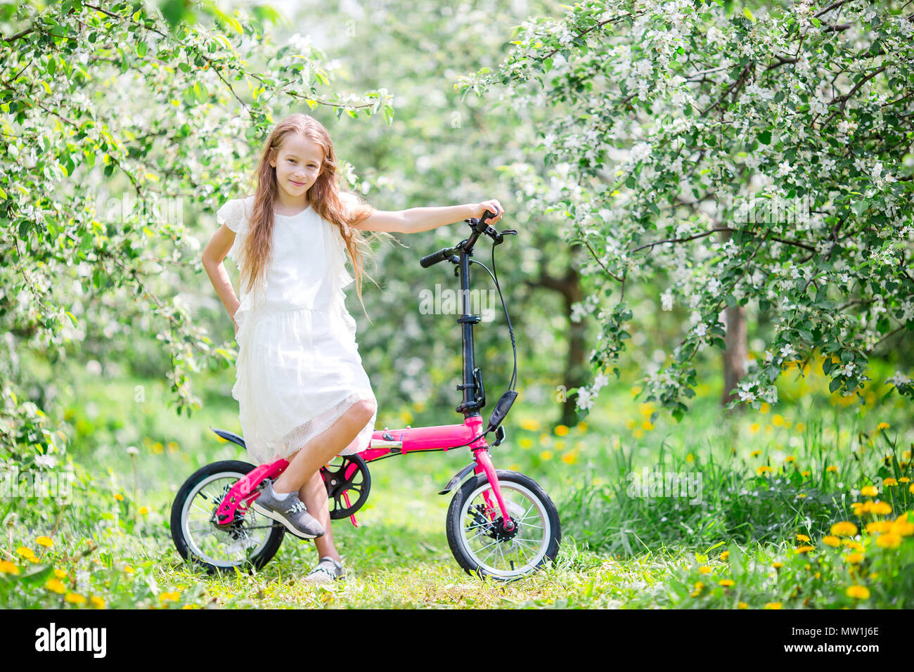 Adorable girl riding a bike at beautiful summer day outdoors Stock ...