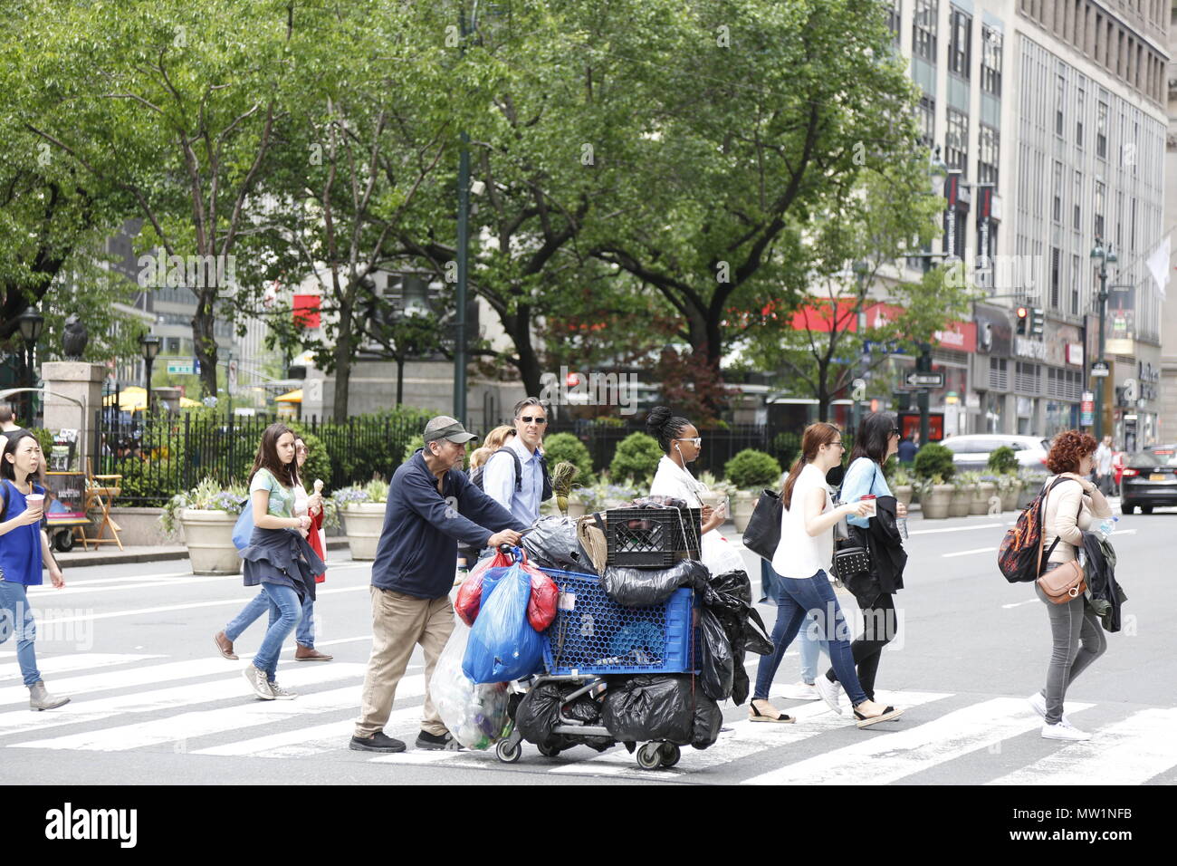 Homeless man pushes a cart full of belongoings and soda cans across 6th ...