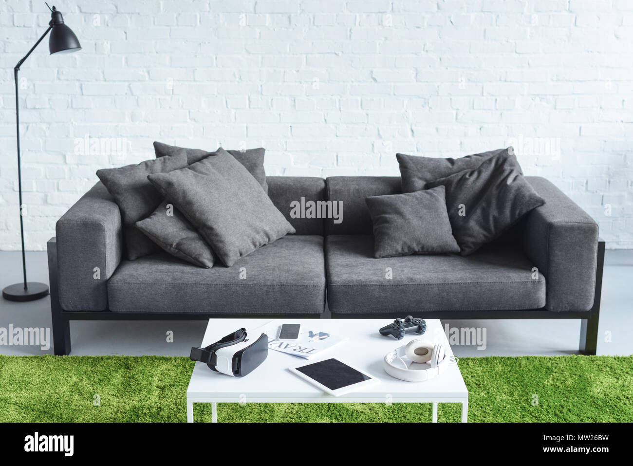 Digital gadgets in cozy interior with modern grey sofa Stock Photo - Alamy