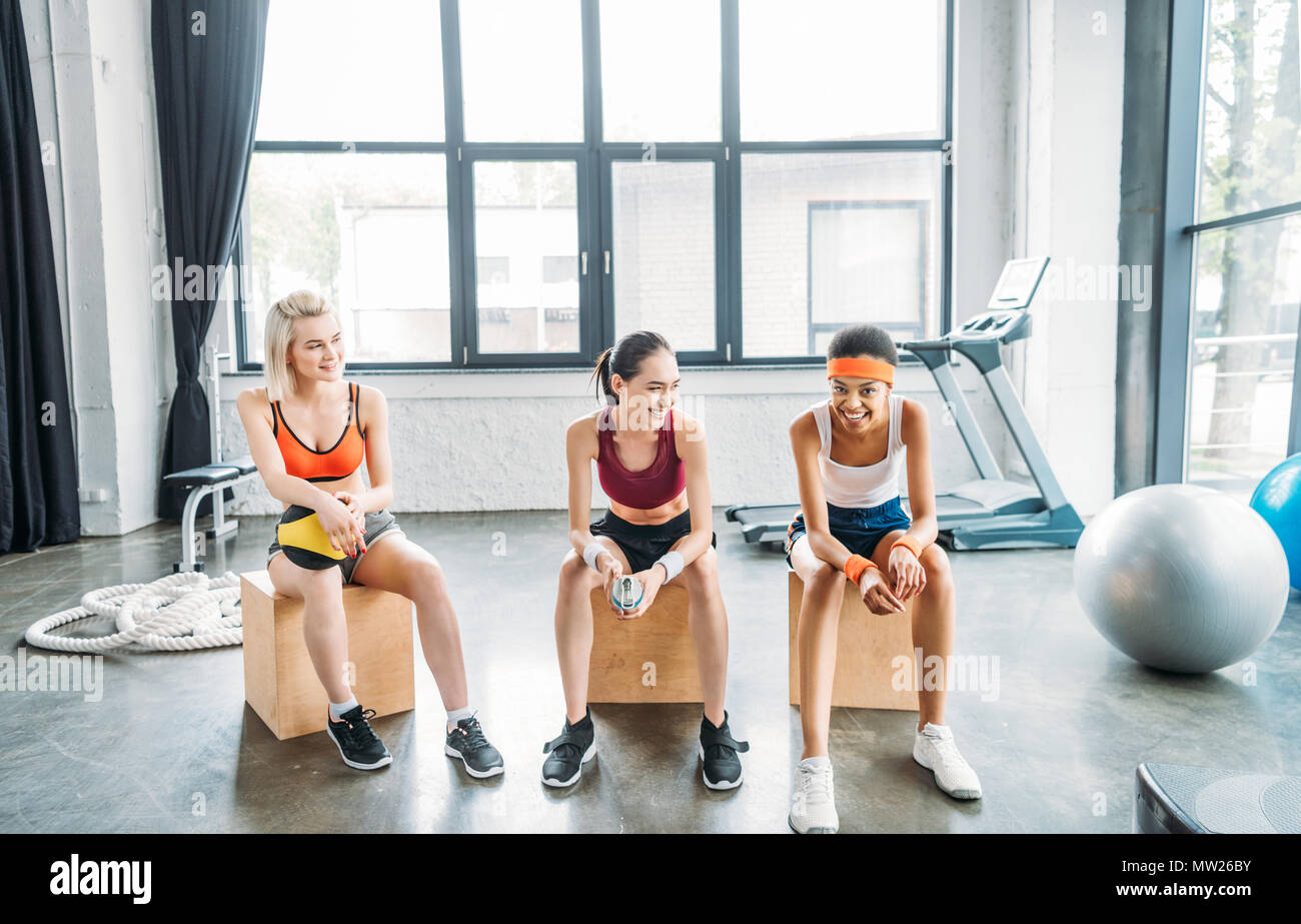three happy multicultural resting on wooden boxes at gym Stock Photo ...