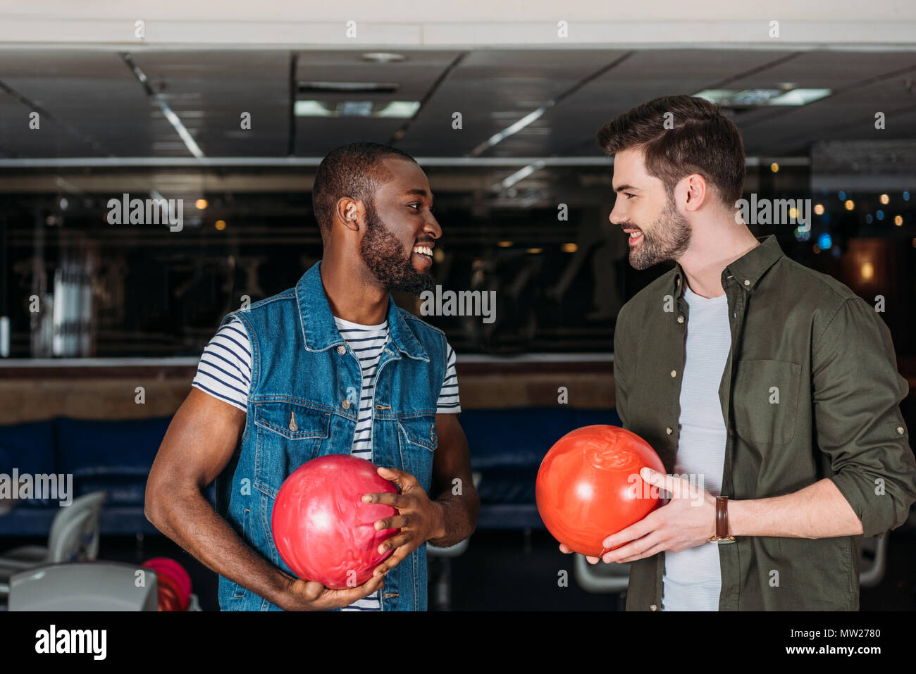 happy young men with balls at bowling club Stock Photo - Alamy