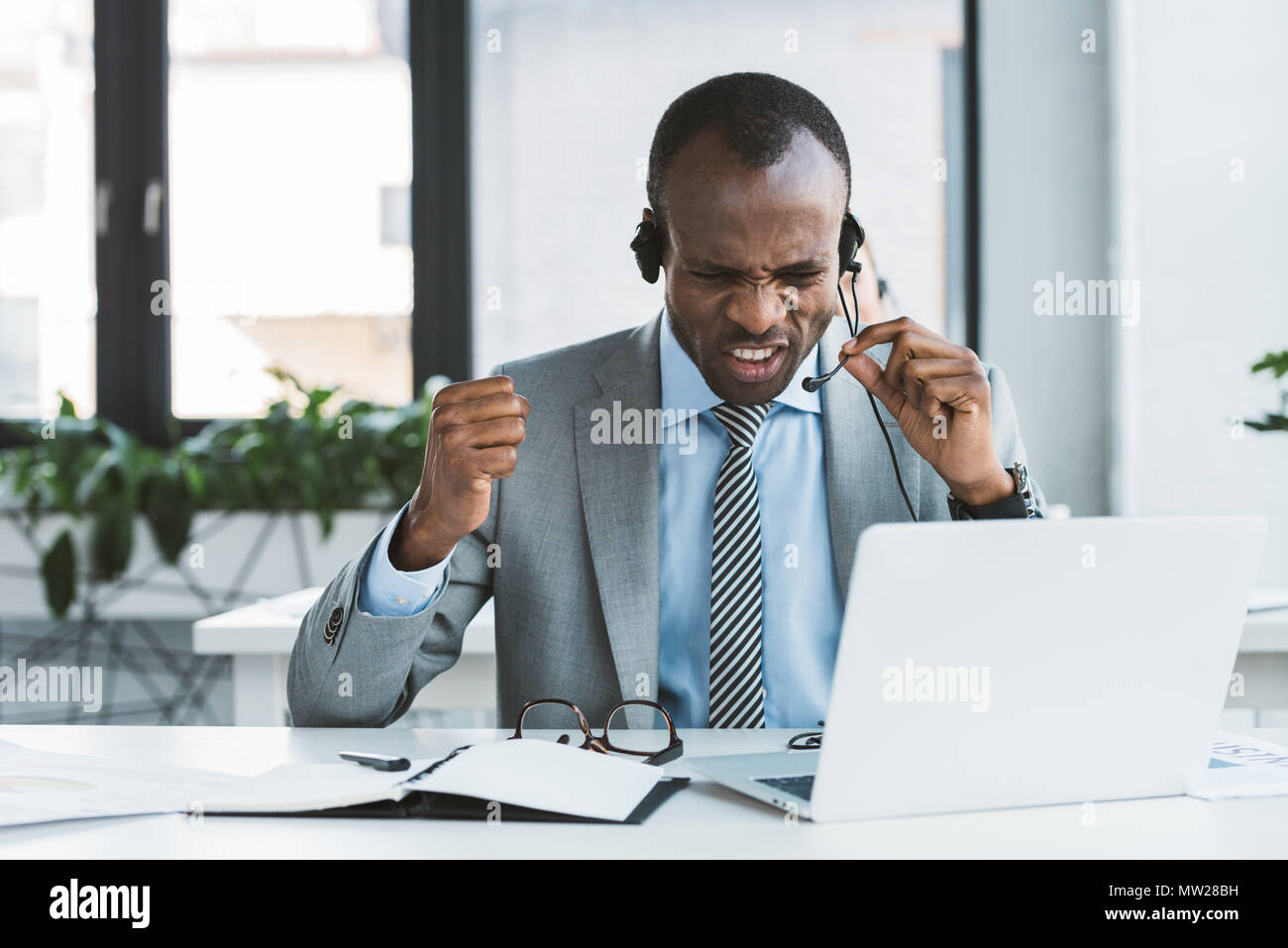 emotional african american businessman yelling at headset at workplace ...