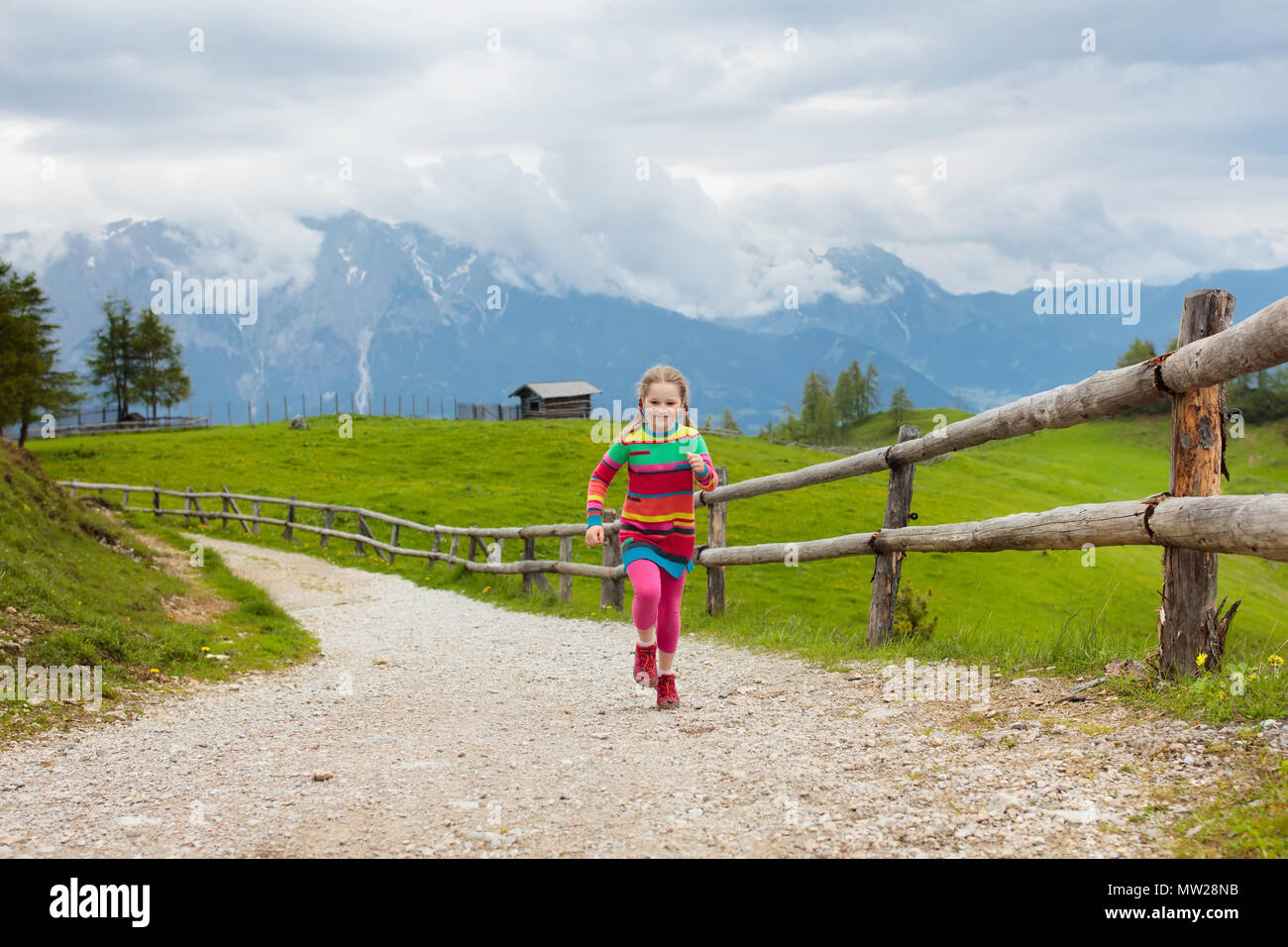Children hiking in Alps mountains. Kids look at snow covered mountain ...