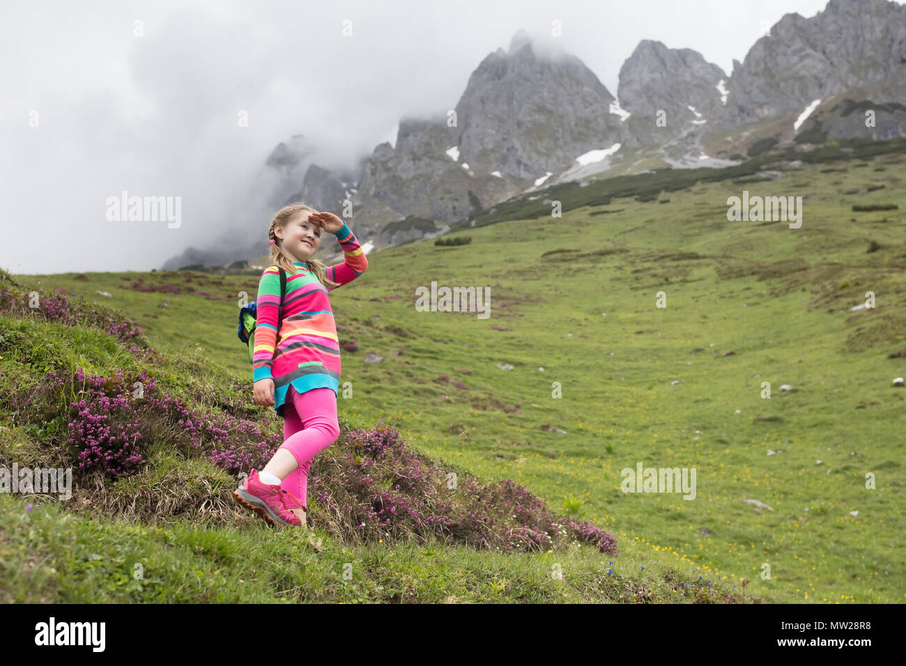 Children hiking in Alps mountains. Kids look at snow covered mountain ...