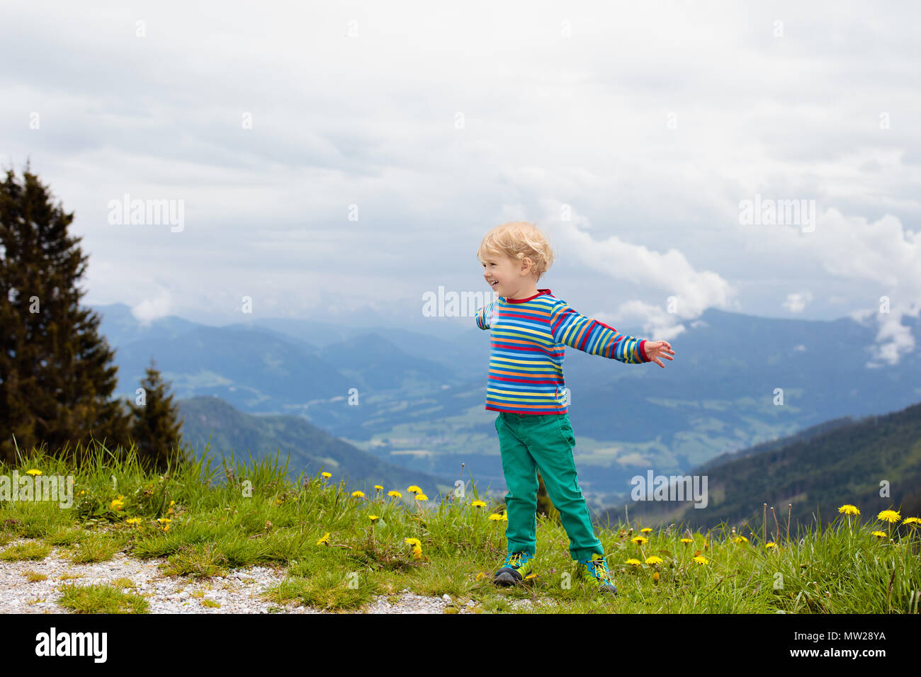Children hiking in Alps mountains. Kids look at snow covered mountain ...