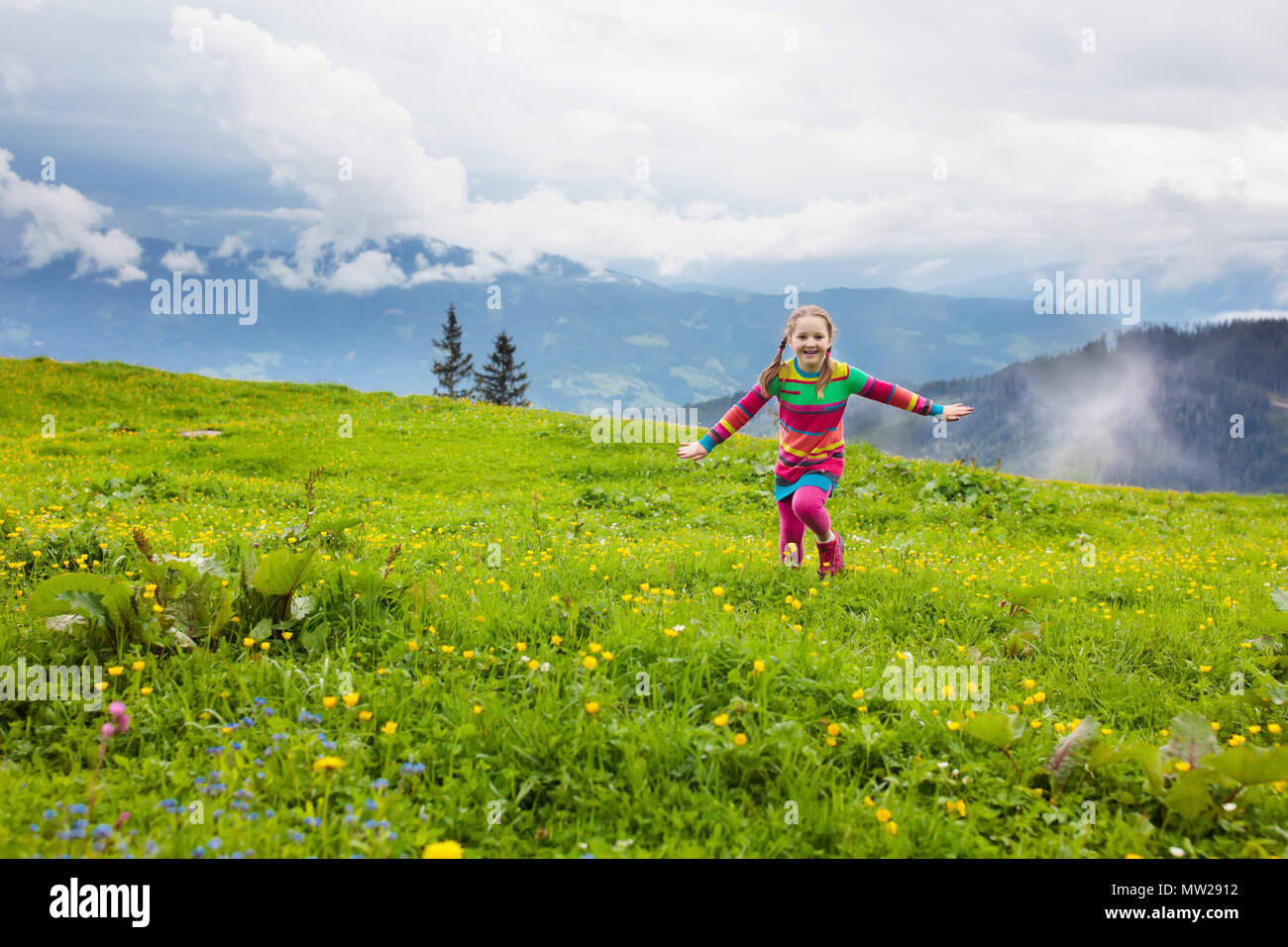 Children hiking in Alps mountains. Kids look at snow covered mountain ...