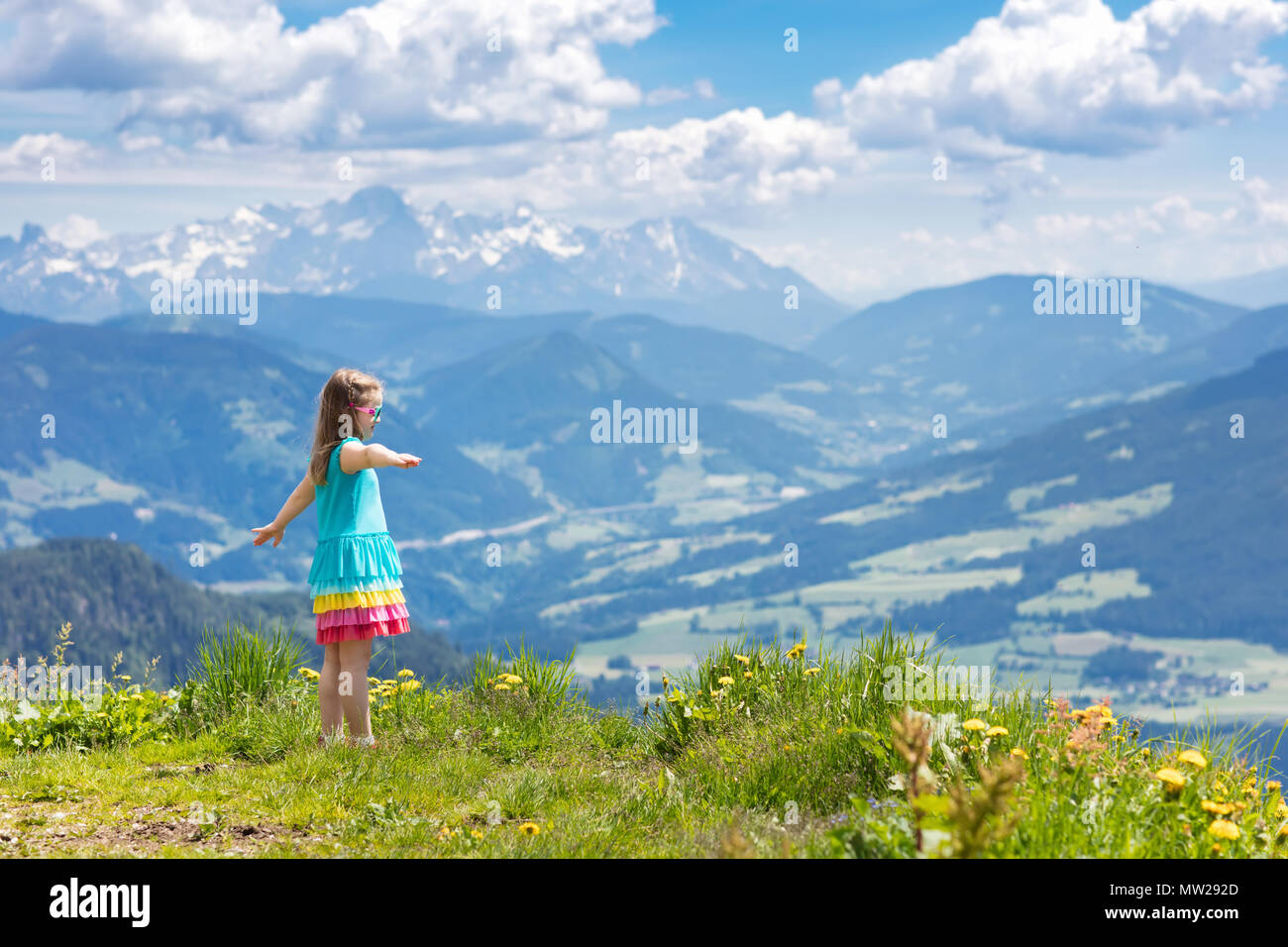 Children hiking in Alps mountains. Kids look at snow covered mountain ...