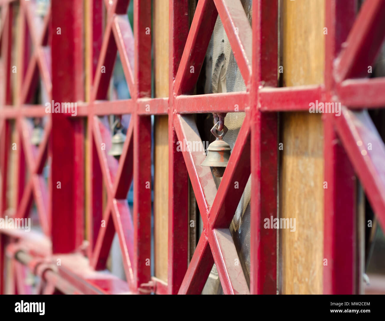 A red wrought-iron gate, with tiny metallic bells affixed to it, at the ...
