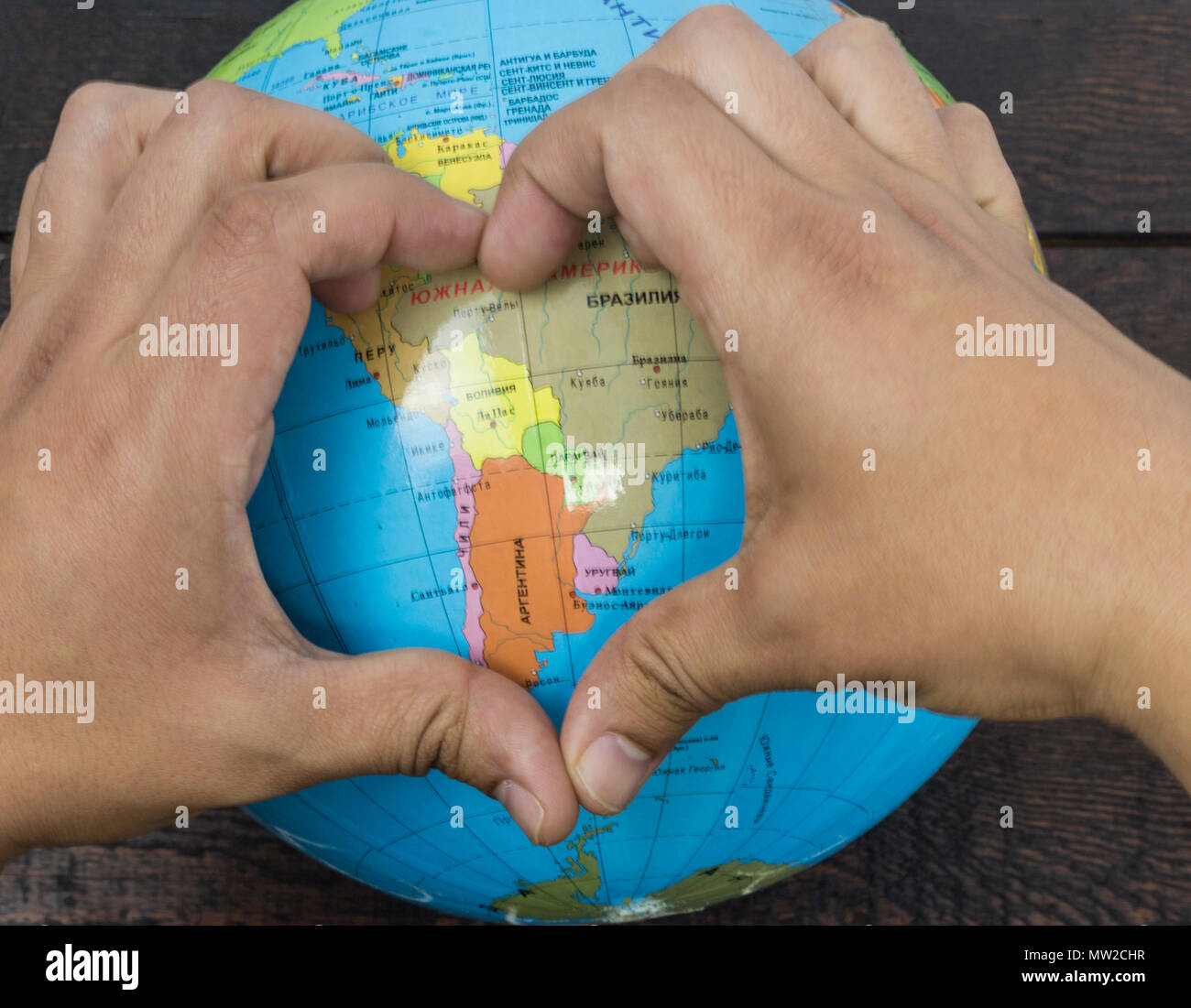 the hands of man forming a heart on world map Stock Photo - Alamy