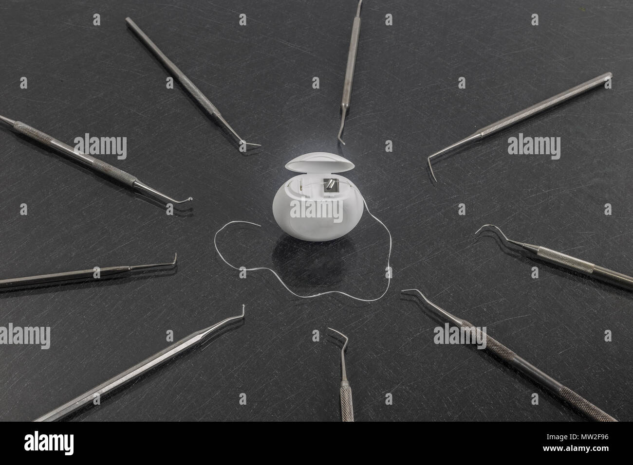 Dental floss with different dental instruments on a gray background ...