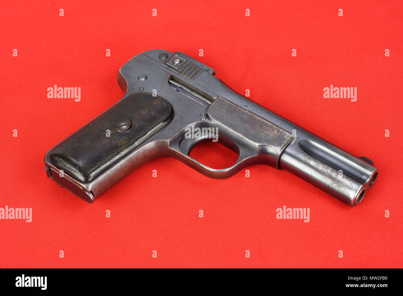 Old rusty handgun on red background Stock Photo - Alamy