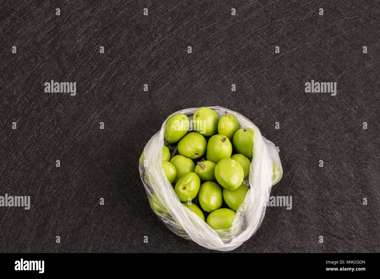 Fresh green apricots in package on black background Stock Photo - Alamy