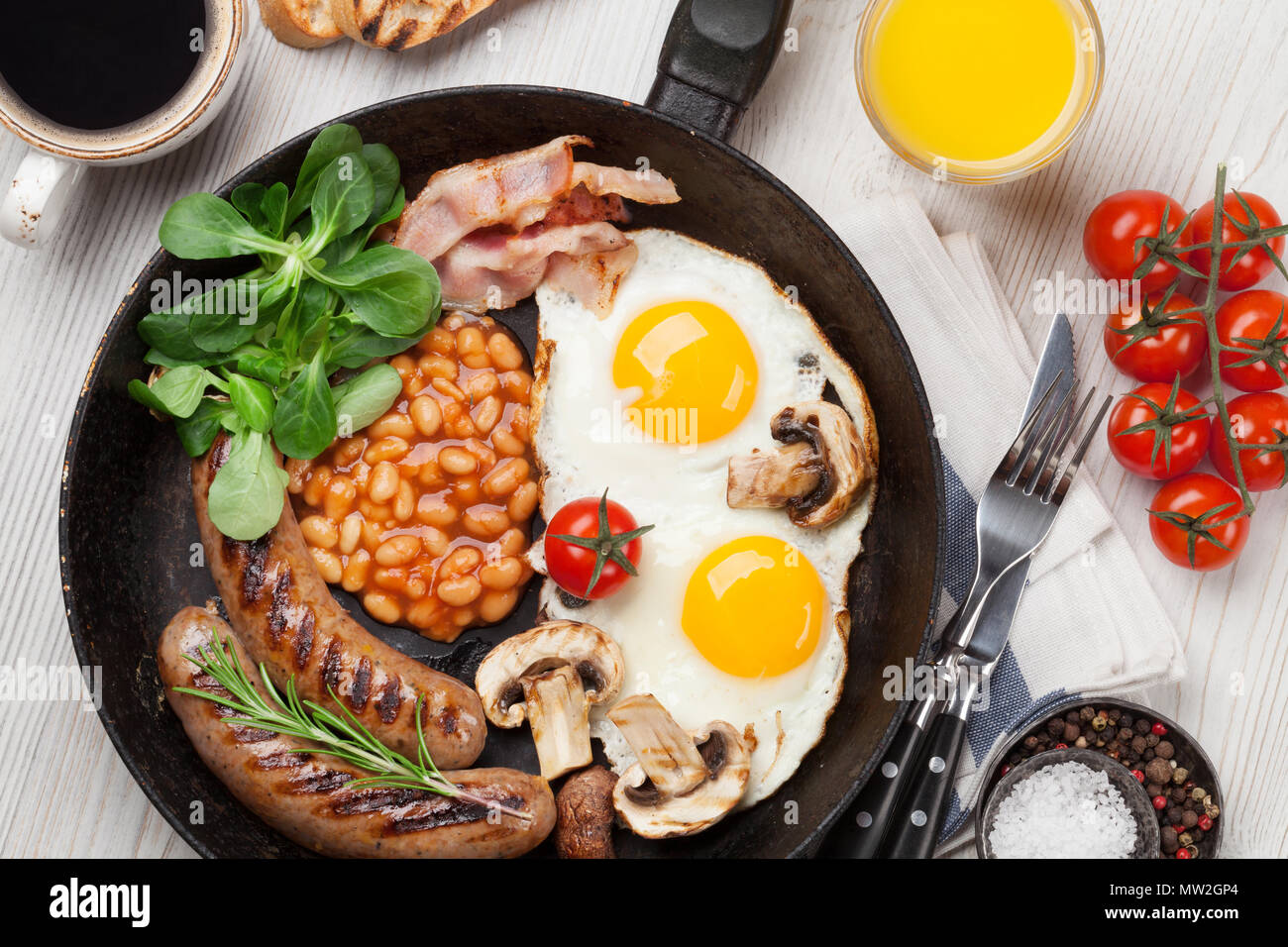 English breakfast. Fried eggs, sausages, bacon, beans, toasts, tomatoes ...