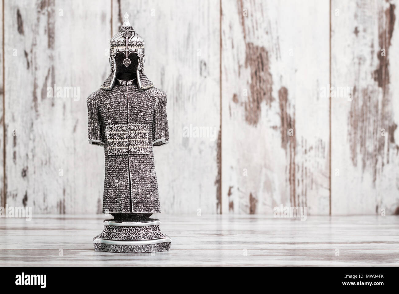 Silver Religious statuette designed as armor on white wooden background ...