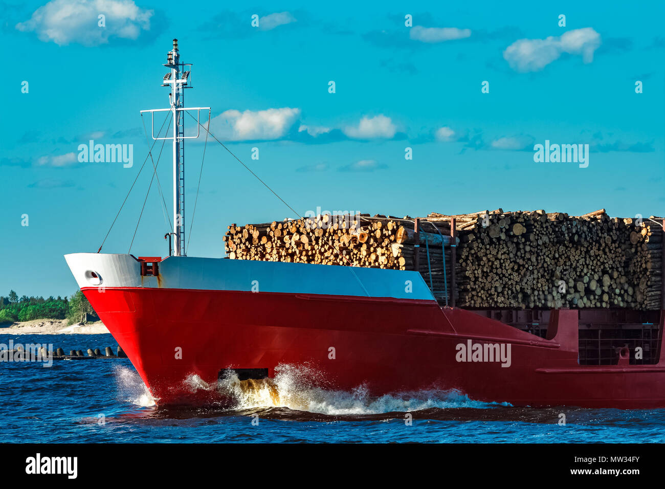 Red cargo ship fully loaded with wood moving at clear day Stock Photo ...