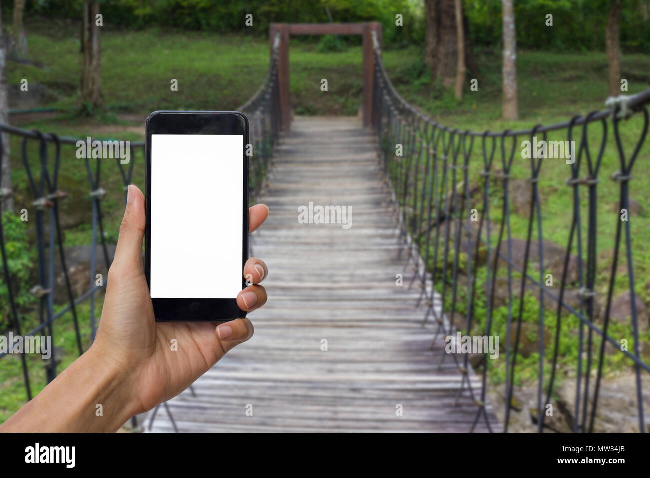 Hand holding black smartphone with white screen for mock up on rope ...