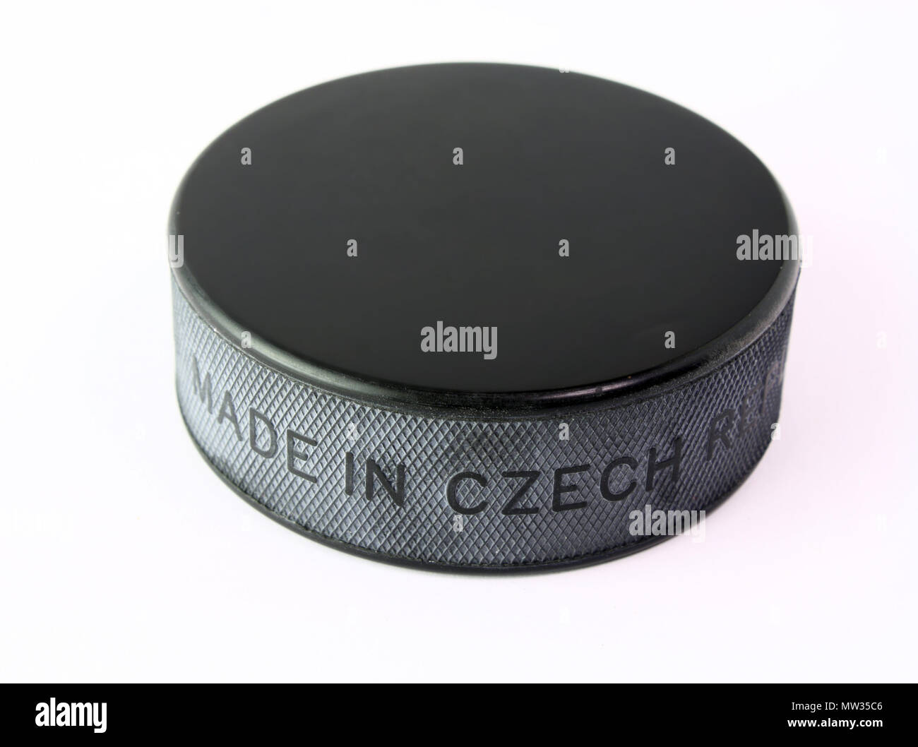 A black hockey puck isolated on white background Stock Photo - Alamy