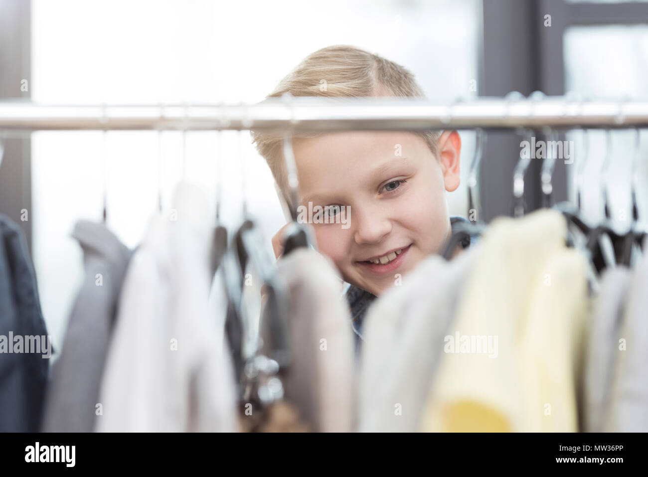 smiling caucasian boy looking on clothes at store Stock Photo - Alamy