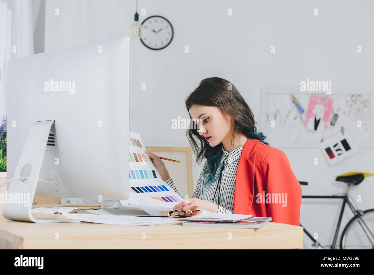 Female designer working with palette by working table with computer ...