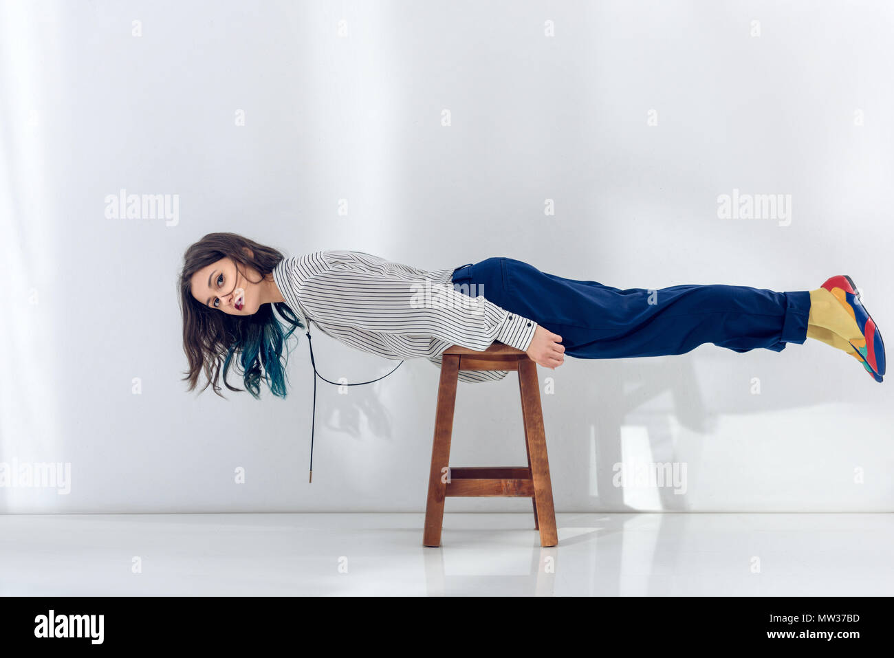 Young girl lying on wooden chair Stock Photo - Alamy
