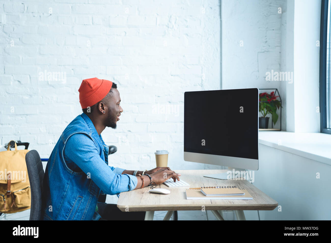 African american man typing on keyboard by working table Stock Photo ...
