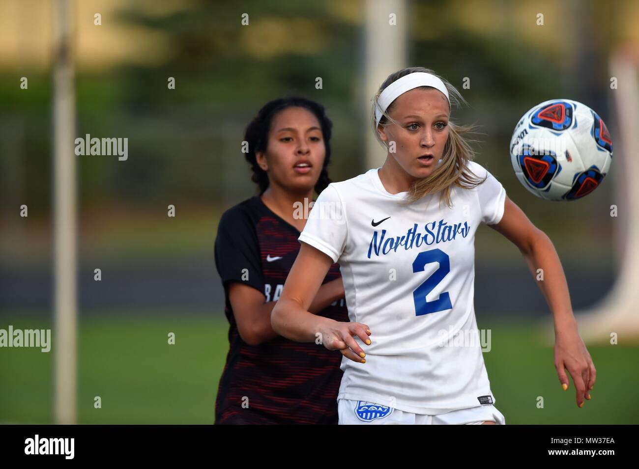 Following a throw in, a player attempts to play the ball off her body ...