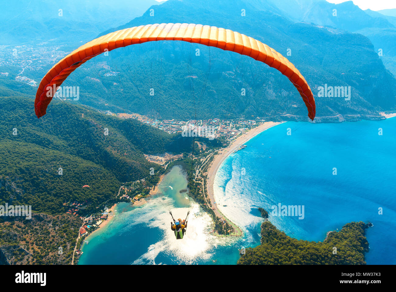 Paragliding in the sky. Paraglider tandem flying over the sea with blue ...