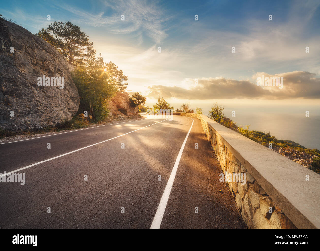 Mountain road at sunset in Europe. Landscape with rocks, sunny sky with ...