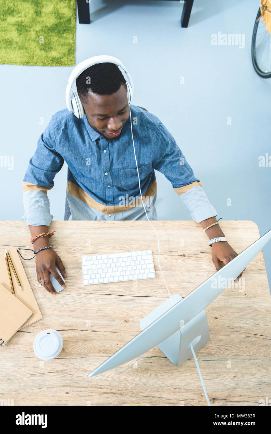 African american man working by computer table Stock Photo - Alamy